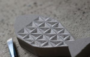Carving a triangle pattern on the stone to represent fish scales